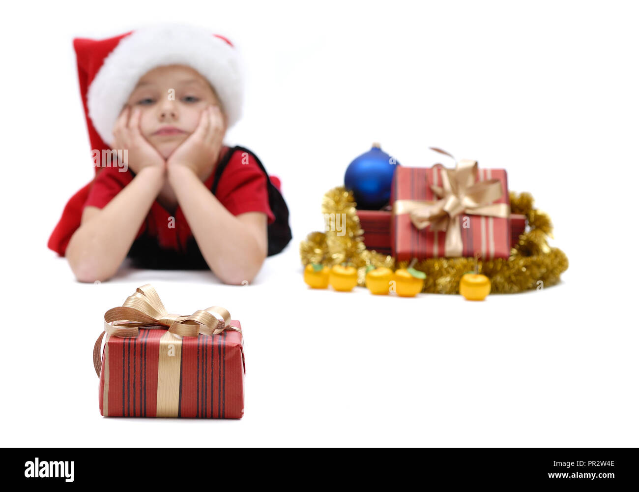 Cute little girl in a Santa Claus cap with Christmas gifts on a white ...