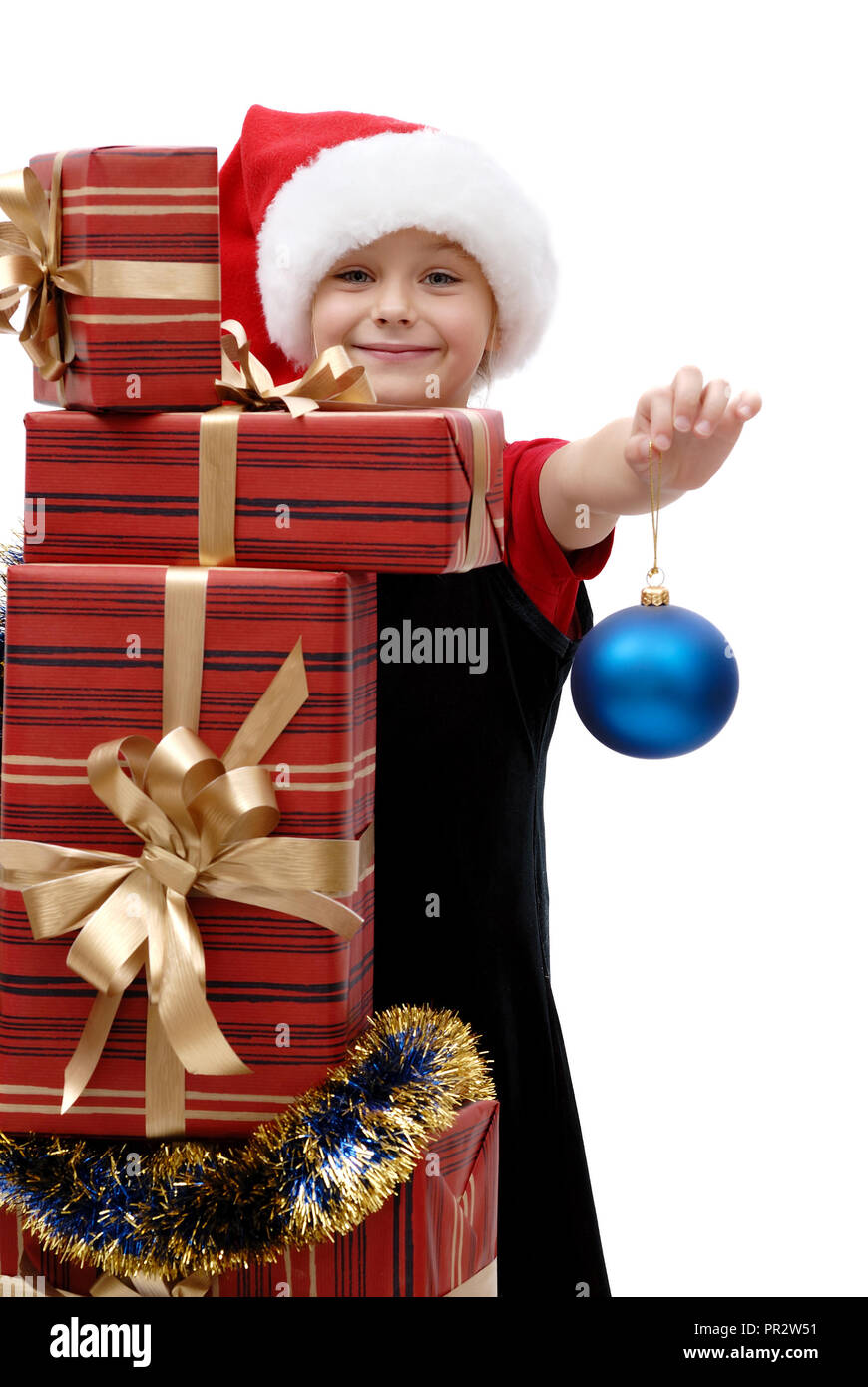 Cute little girl in a Santa Claus cap with Christmas gifts on a white ...