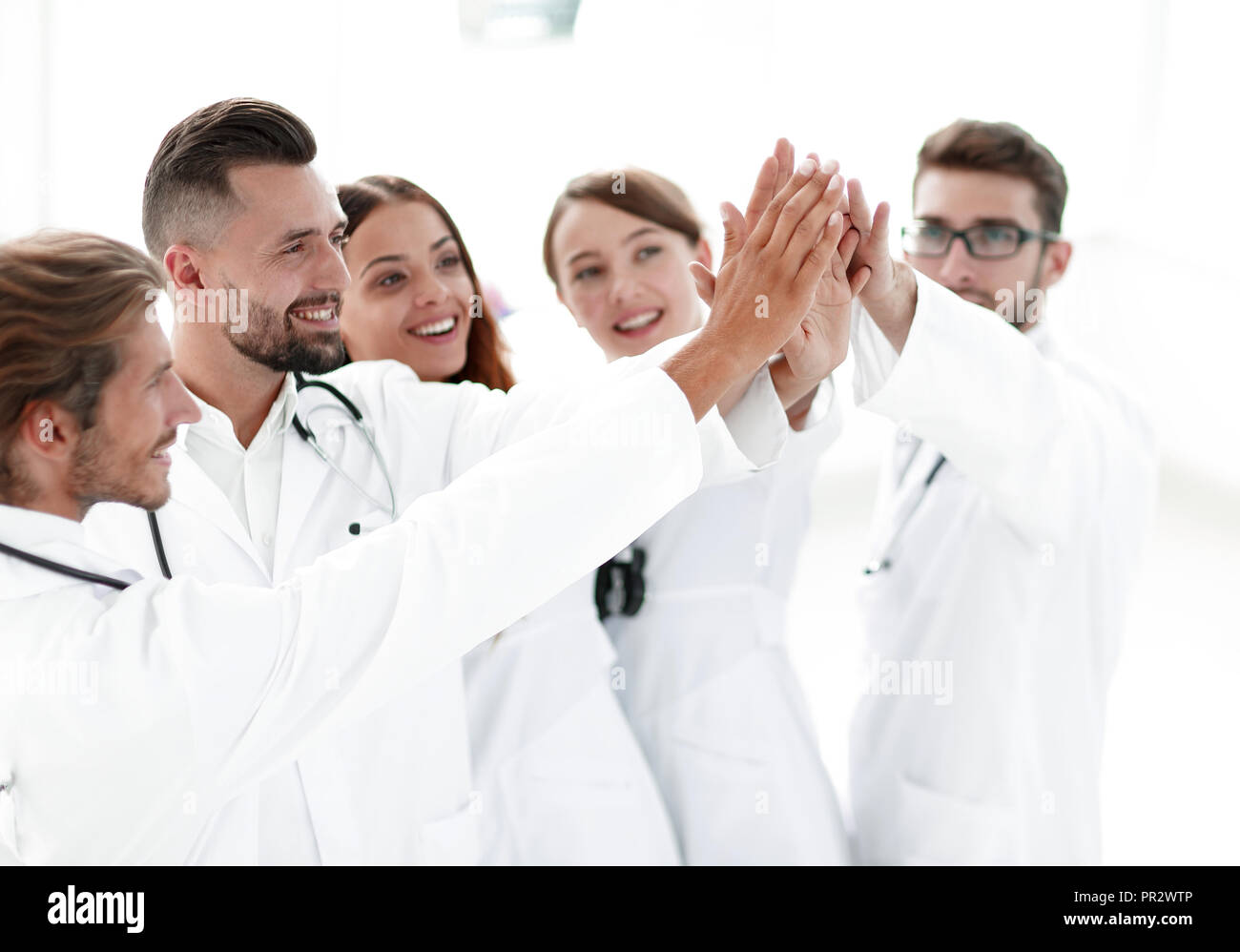 group of doctors giving each other a high five Stock Photo - Alamy