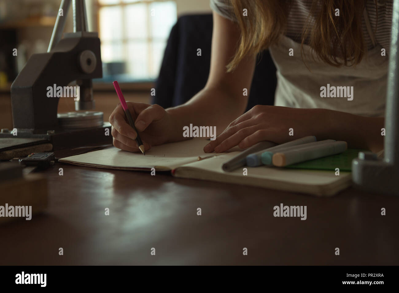 Jewelry designer writing on a register in workshop Stock Photo - Alamy