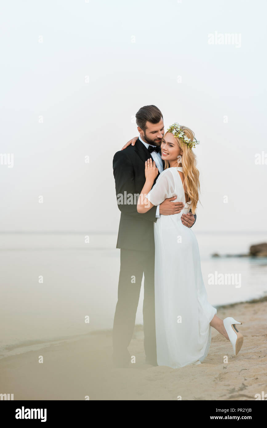 wedding couple cuddling on sandy beach near ocean Stock Photo - Alamy