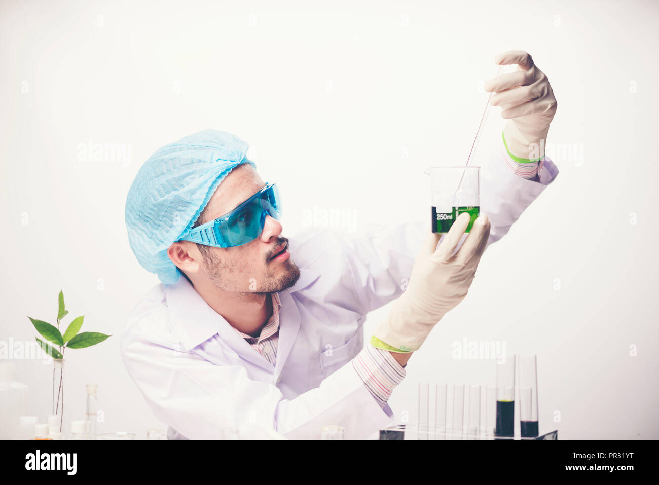 Conical flask in scientist hand with lab glassware background ...