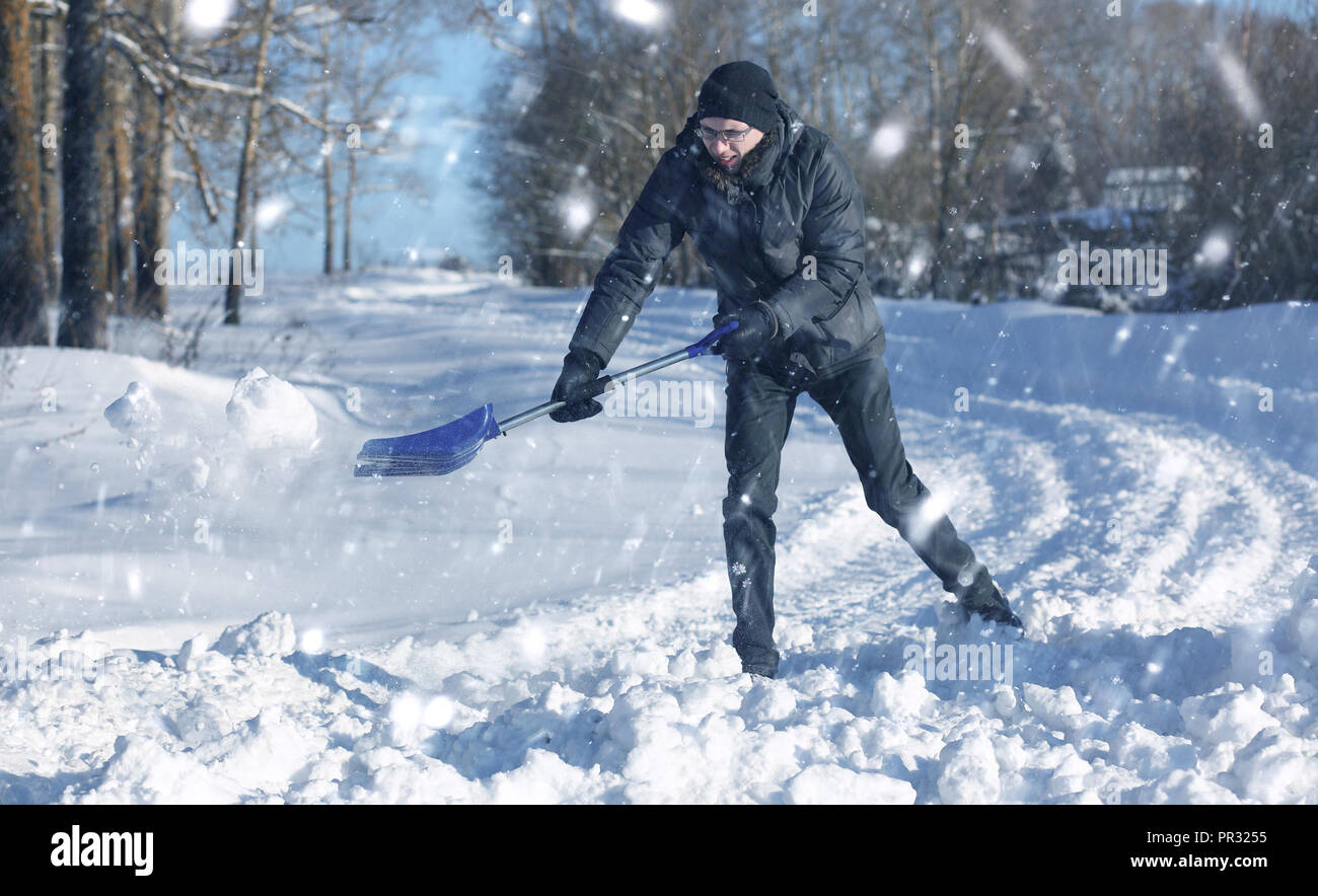 man remove snow with shovel from the road in snowy winter Stock Photo ...