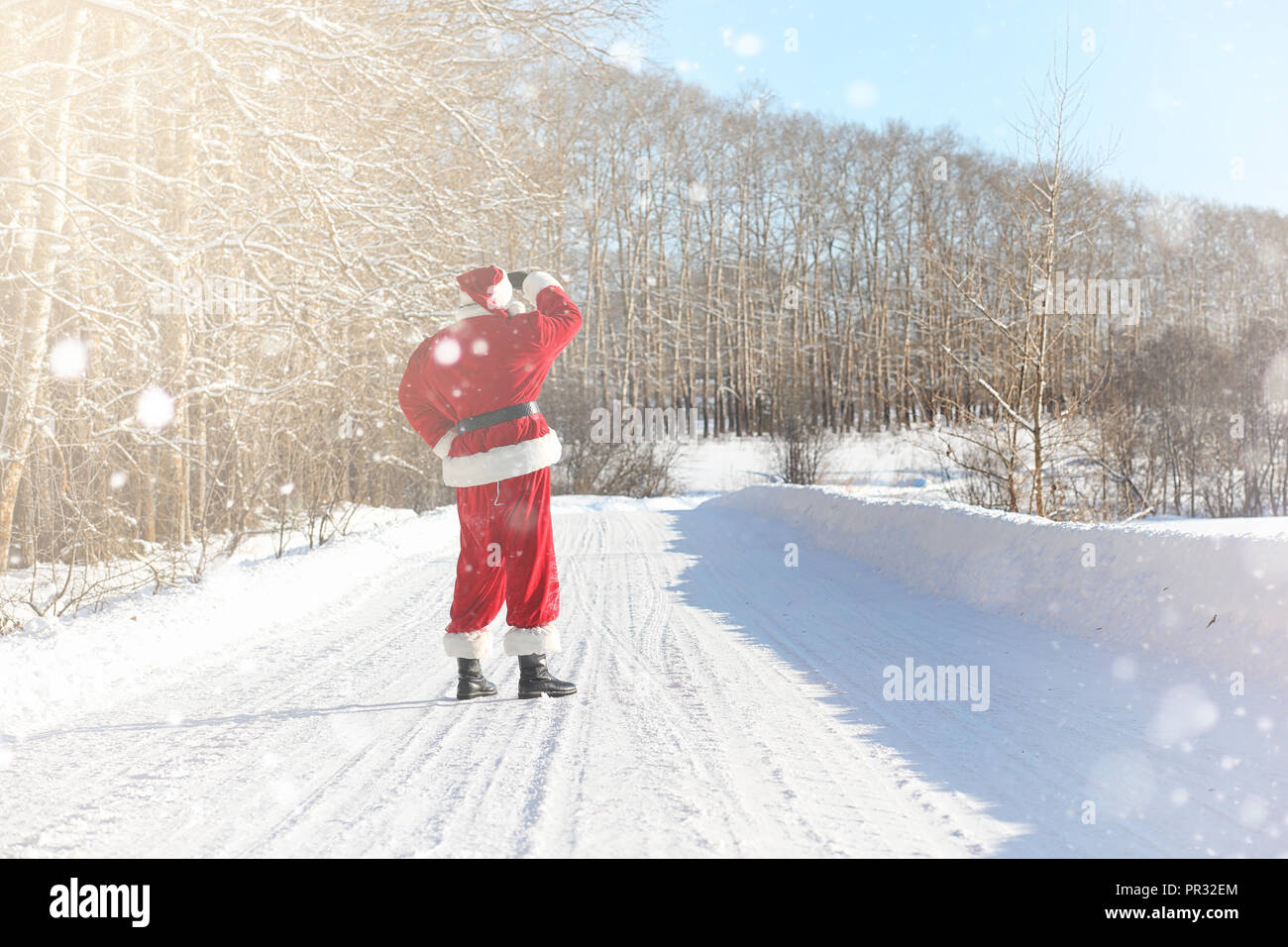 Santa Claus comes with gifts from the outdoor. Santa in a red su Stock ...