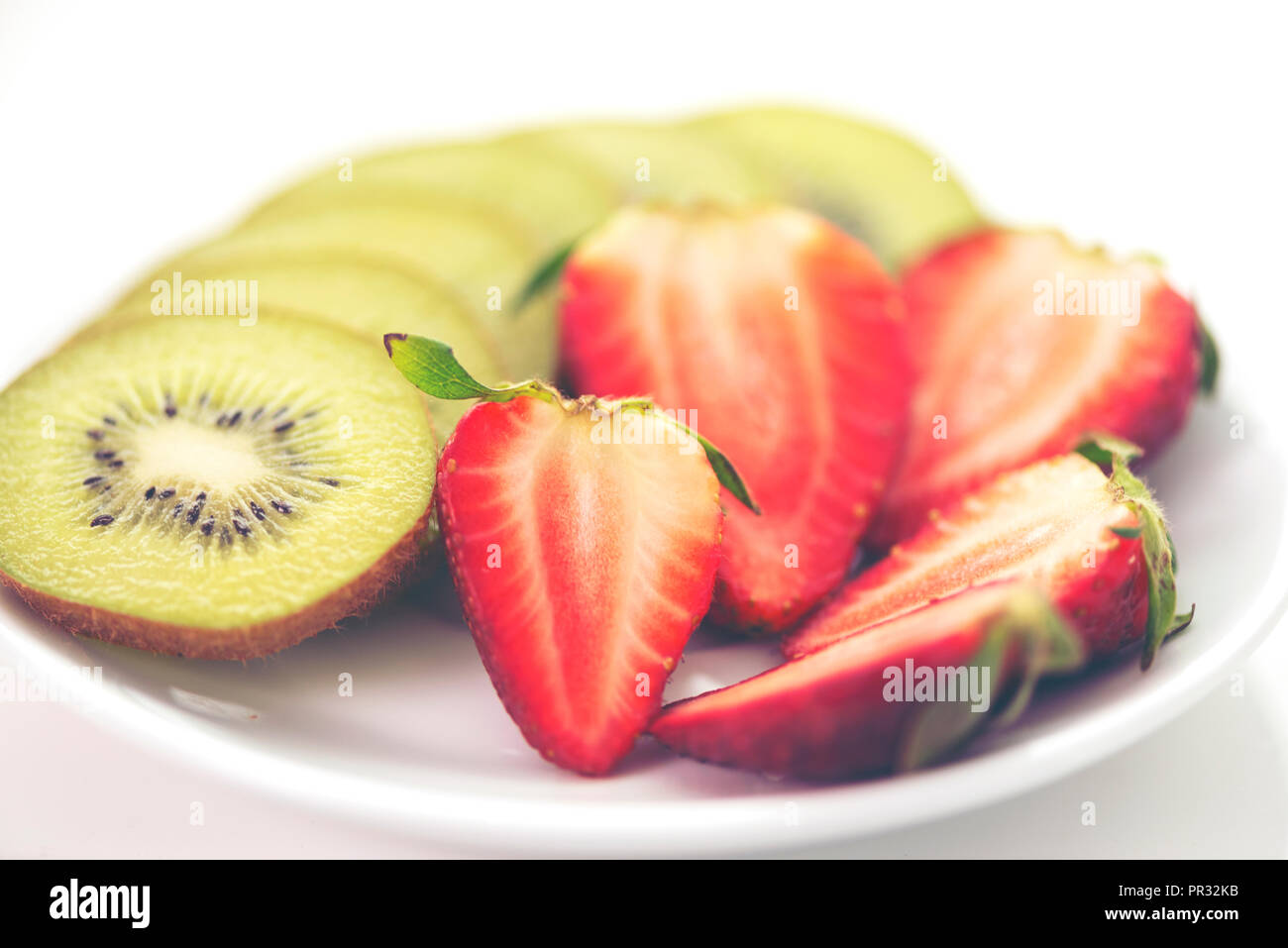 Kiwi and strawberry on plate Stock Photo - Alamy