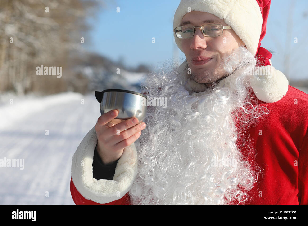 Santa Claus comes with gifts from the outside. Santa in a red su Stock ...