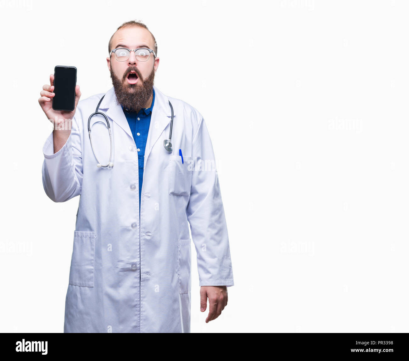 Young doctor man showing smartphone screen over isolated background ...