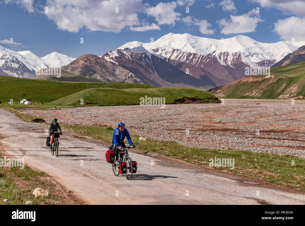 Cyclists on the Pamir Highway descending from the Pamir Mountains into ...