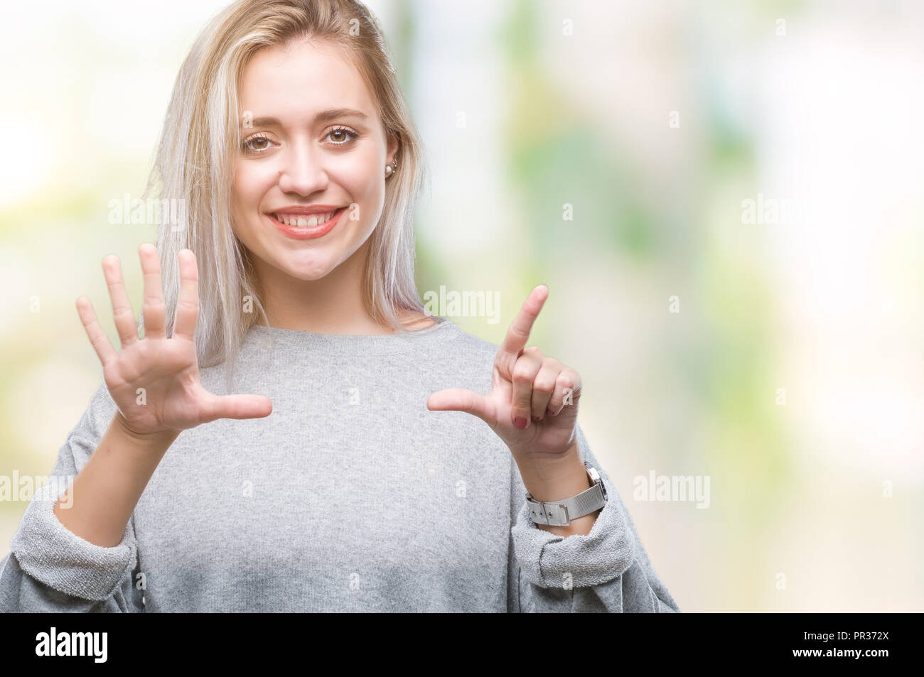 Young blonde woman over isolated background showing and pointing up ...