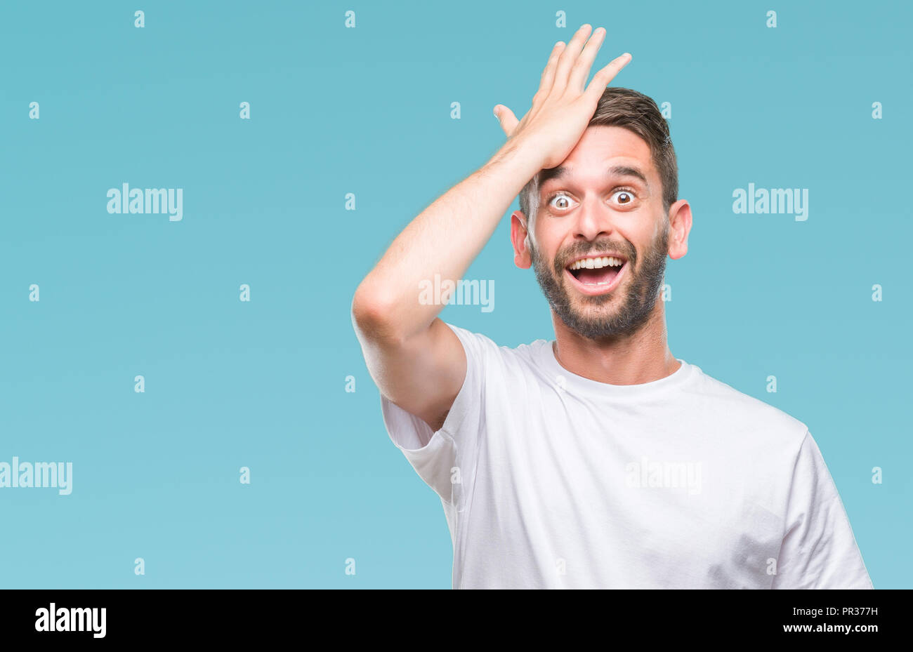 Young handsome man over isolated background surprised with hand on head ...