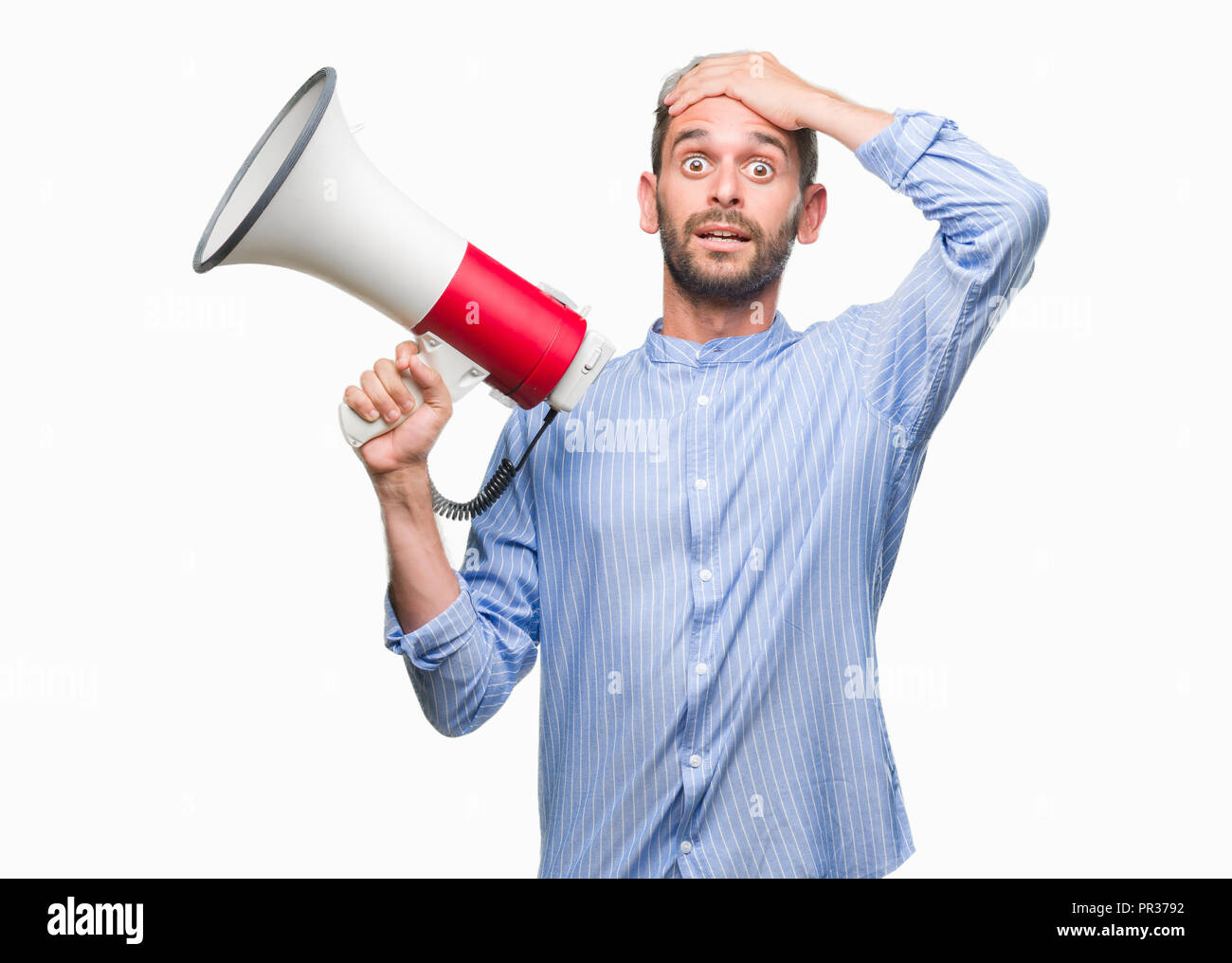 Young handsome man yelling through megaphone over isolated background ...