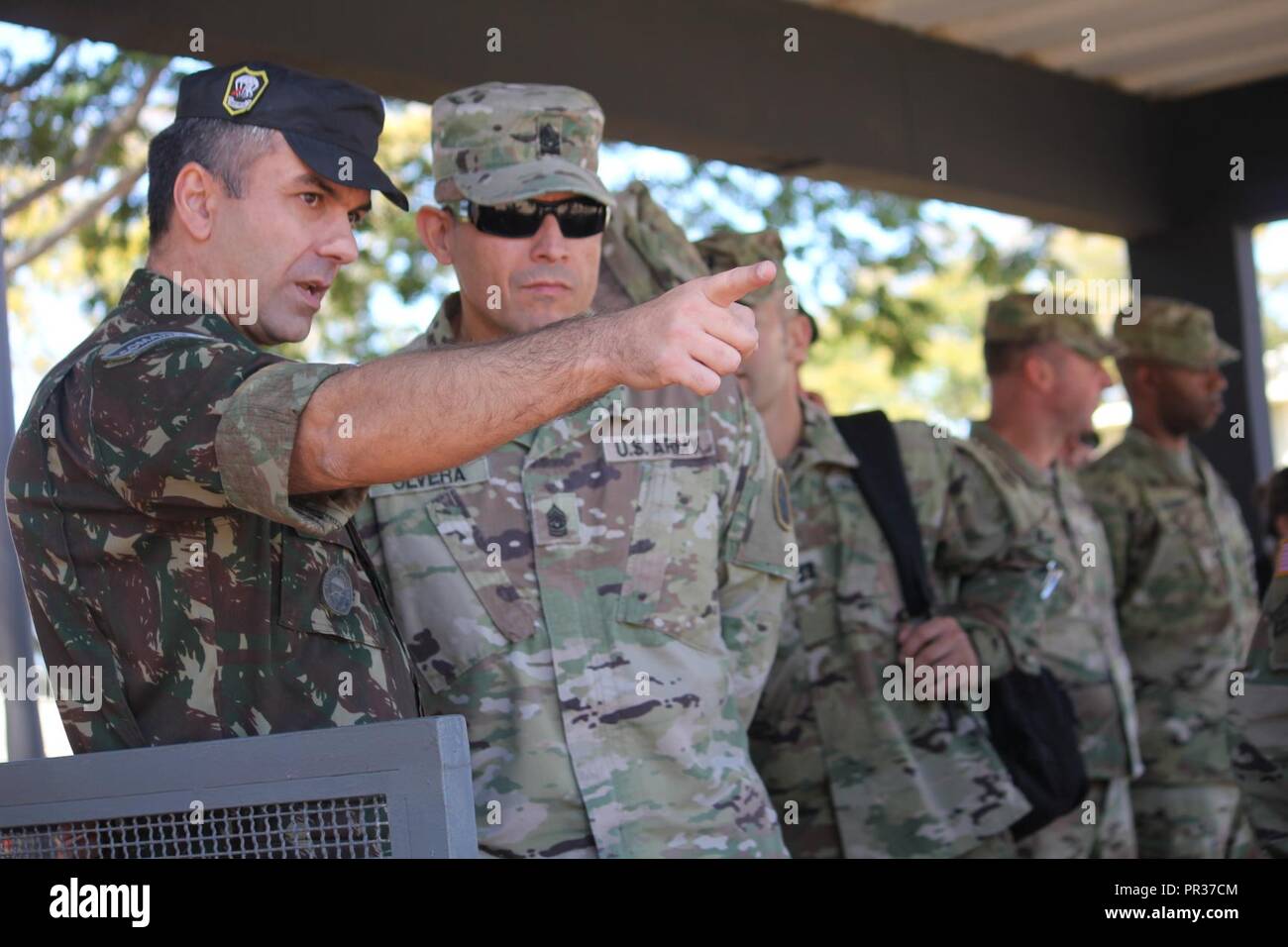 A Brazilian special operator highlights a piece of equipment to Army ...