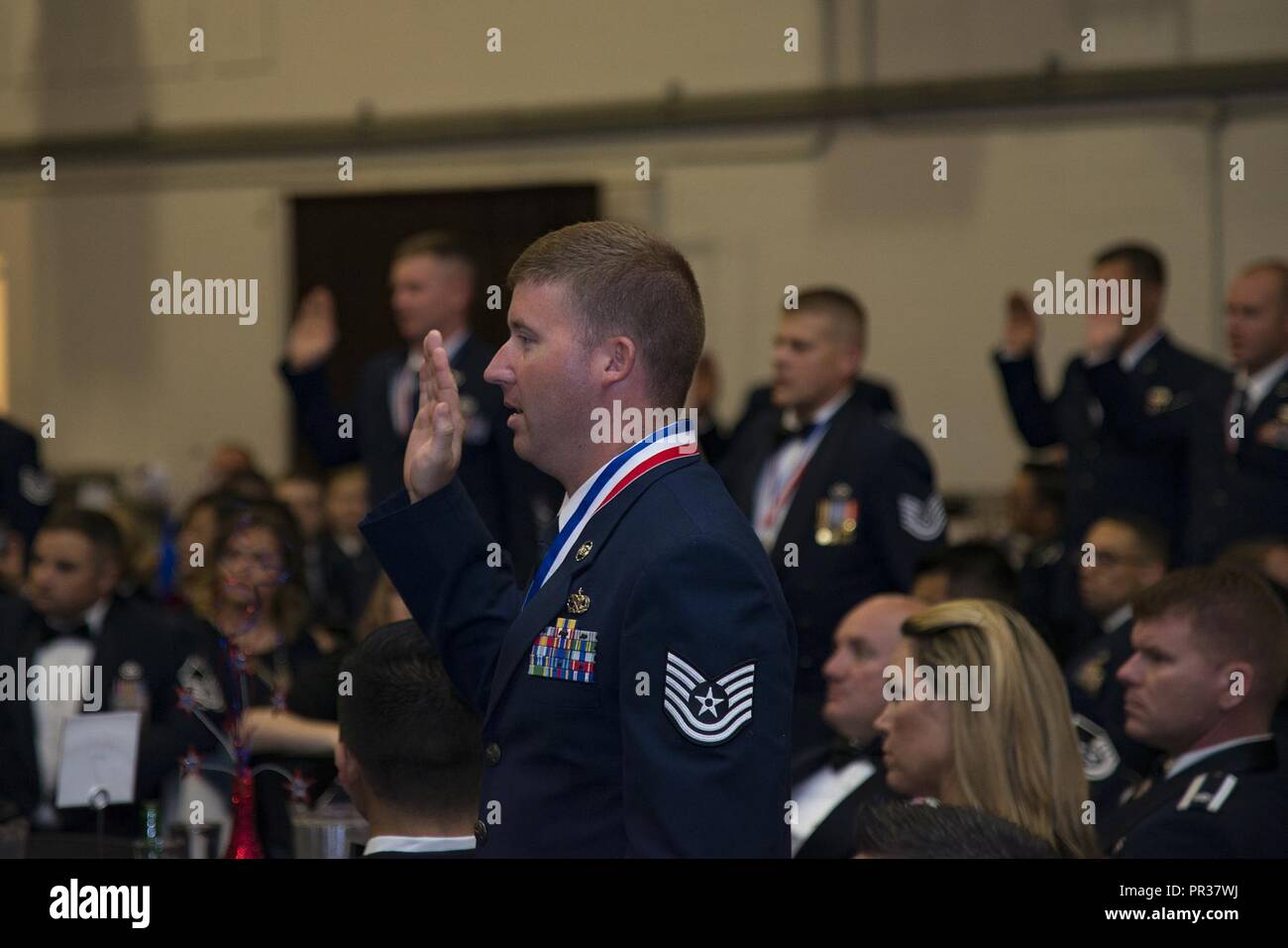 Airmen take an induction charge at a Senior NCO induction ceremony ...