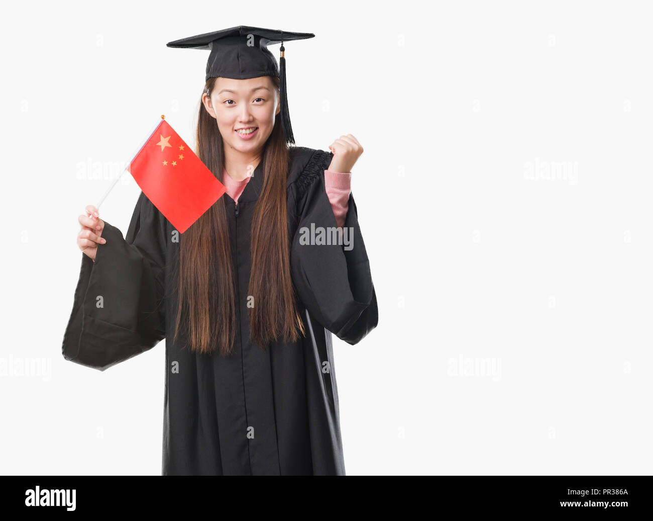Young Chinese woman wearing graduate uniform holding China flag ...