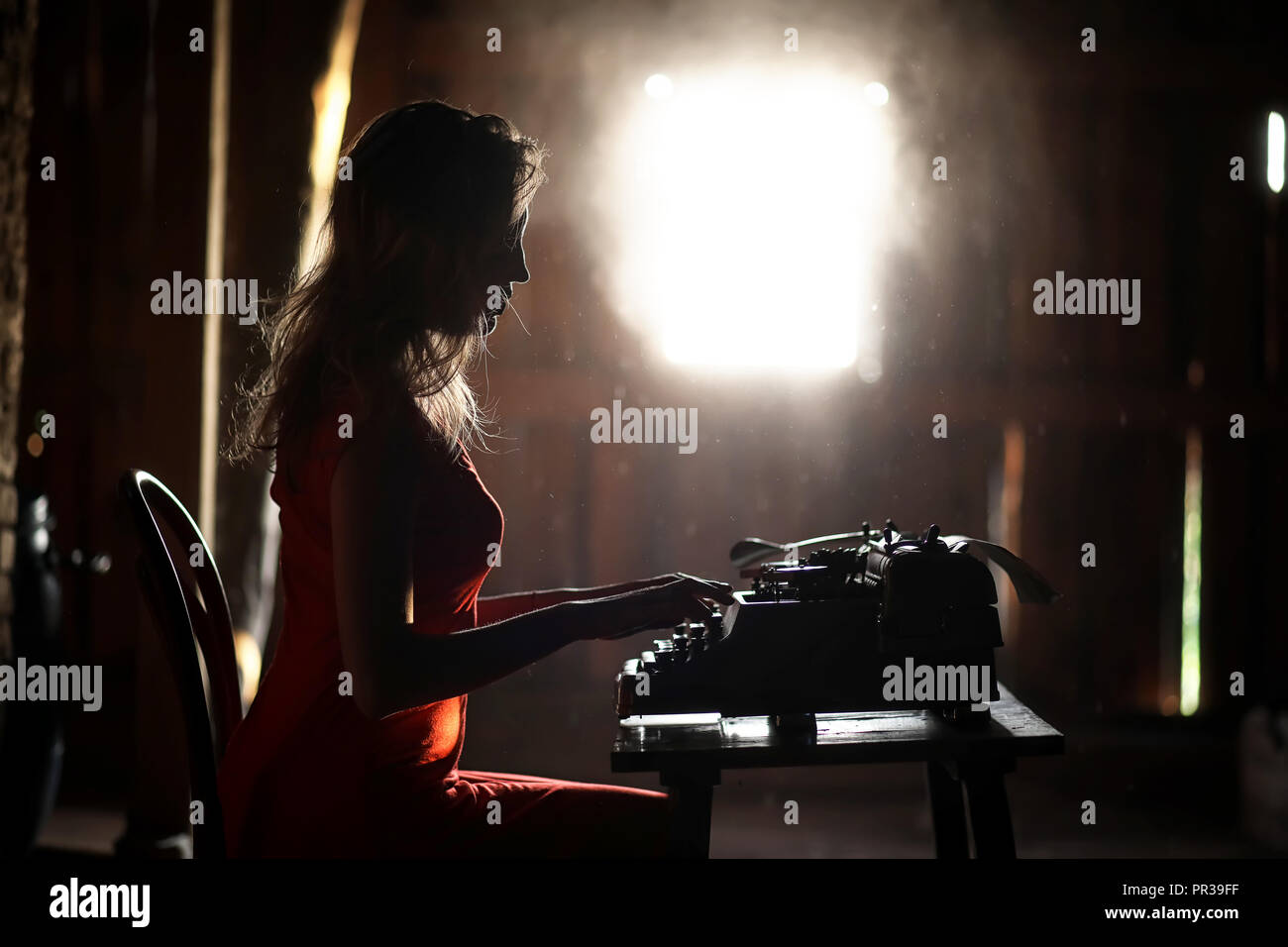 A girl in retro style prints on an old typewriter Stock Photo - Alamy