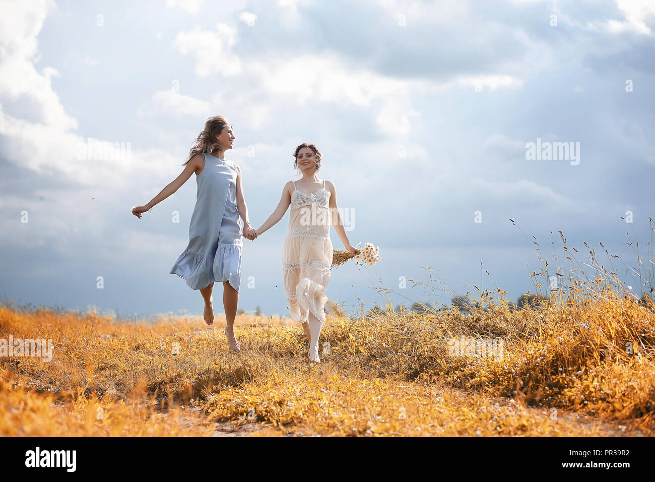 Two girls in dresses in autumn field Stock Photo - Alamy