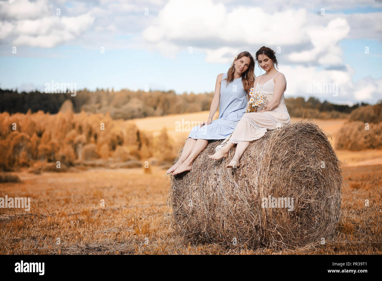 Two girls in dresses in autumn field Stock Photo - Alamy