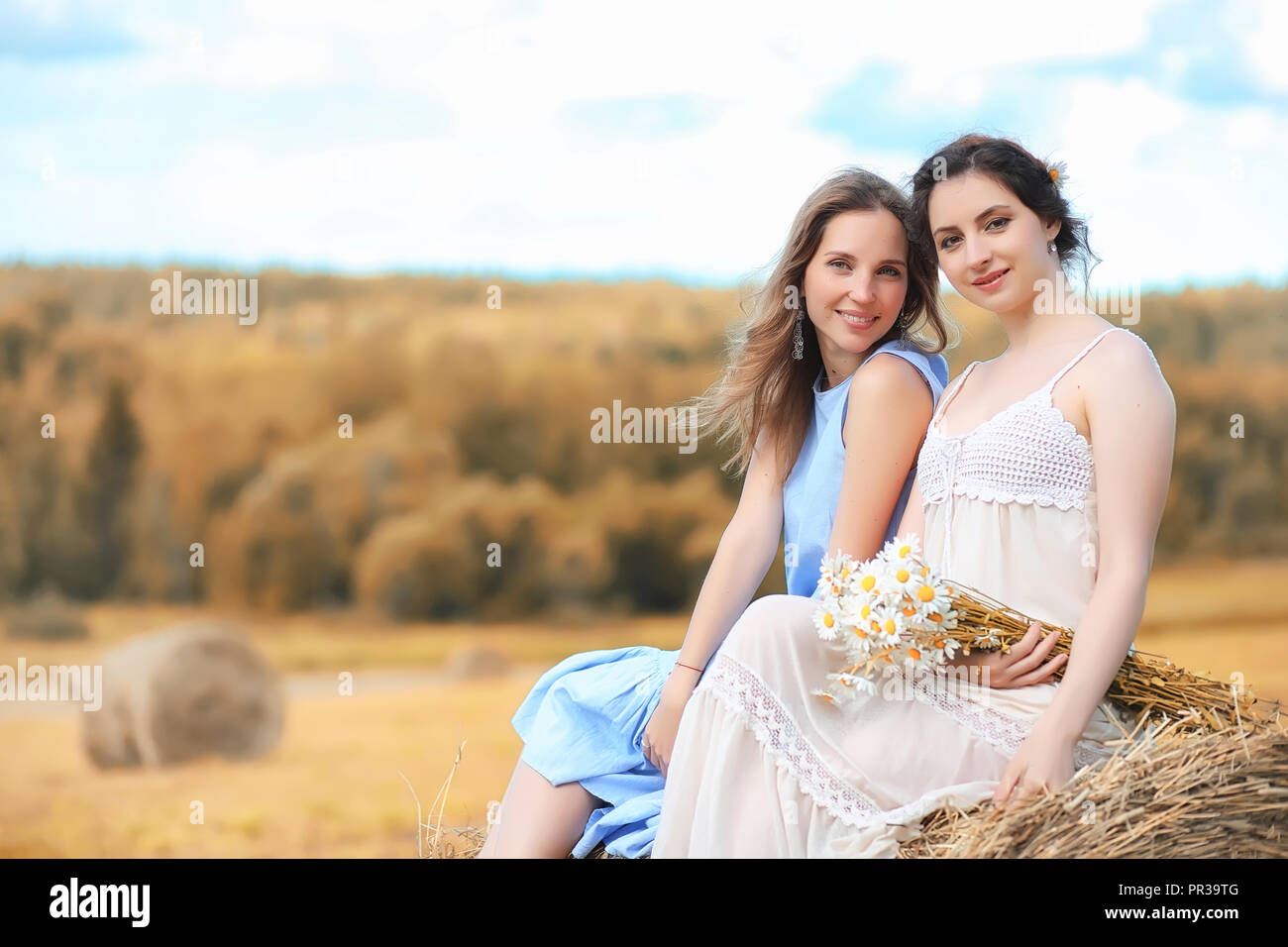Two girls in dresses in autumn field Stock Photo - Alamy