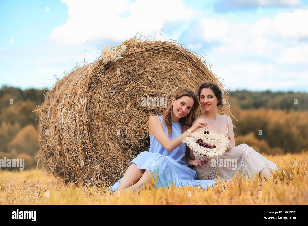 Two girls in dresses in autumn field Stock Photo - Alamy
