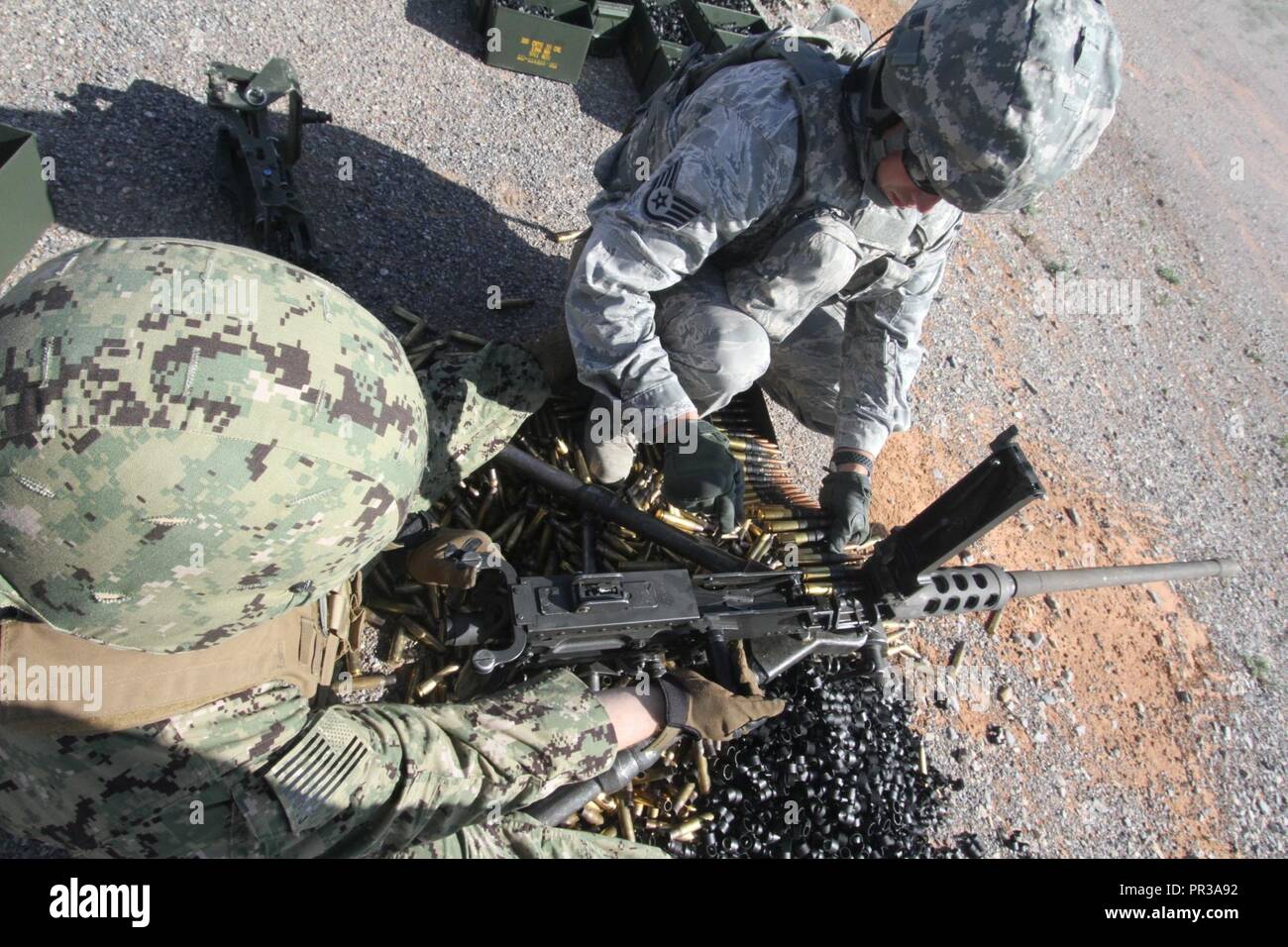 Gunner U.S. Petty Officer 3rd Class Derek Dick waits to charge an M2 ...