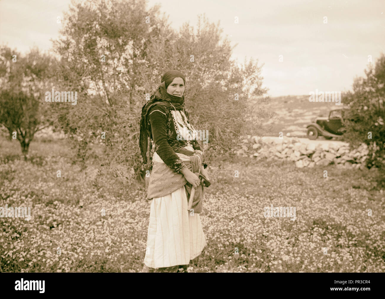 Native woman of Galilee in patch of flowers. 1940 Stock Photo - Alamy