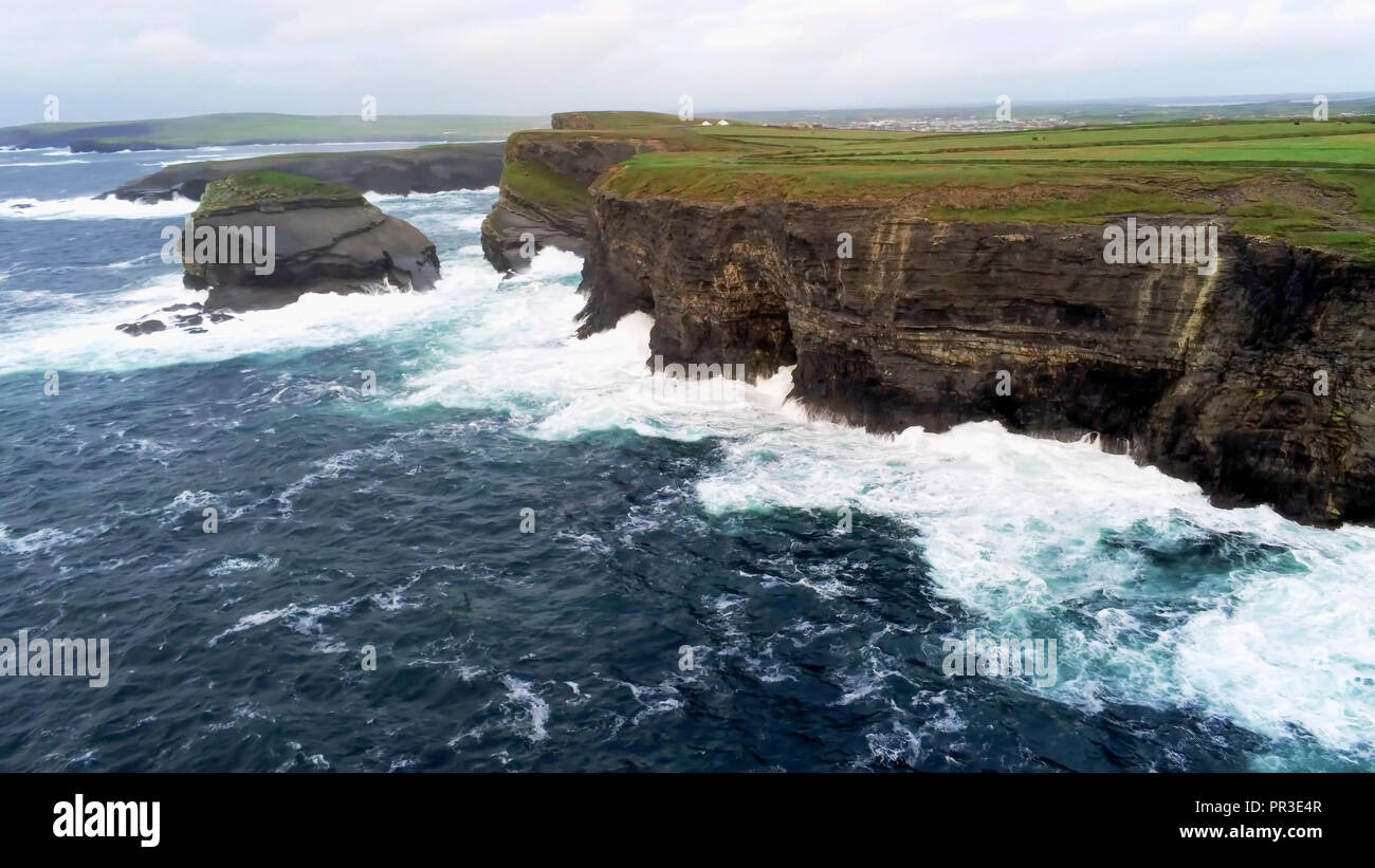 Wild ocean water hits against the steep cliffs of the Irish west coast ...