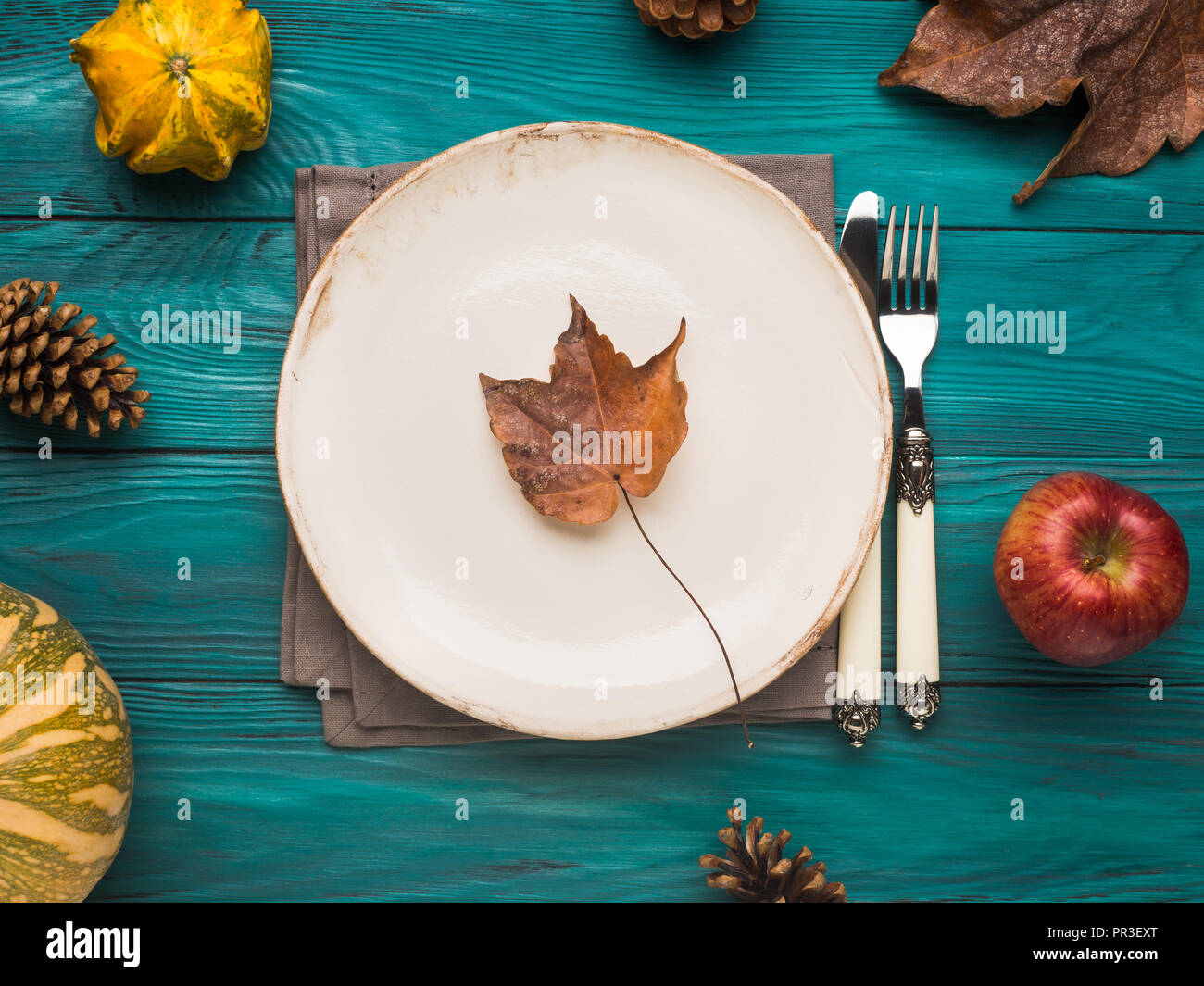 Empty plate on Moody green autumn background with pumpkin and yellow ...