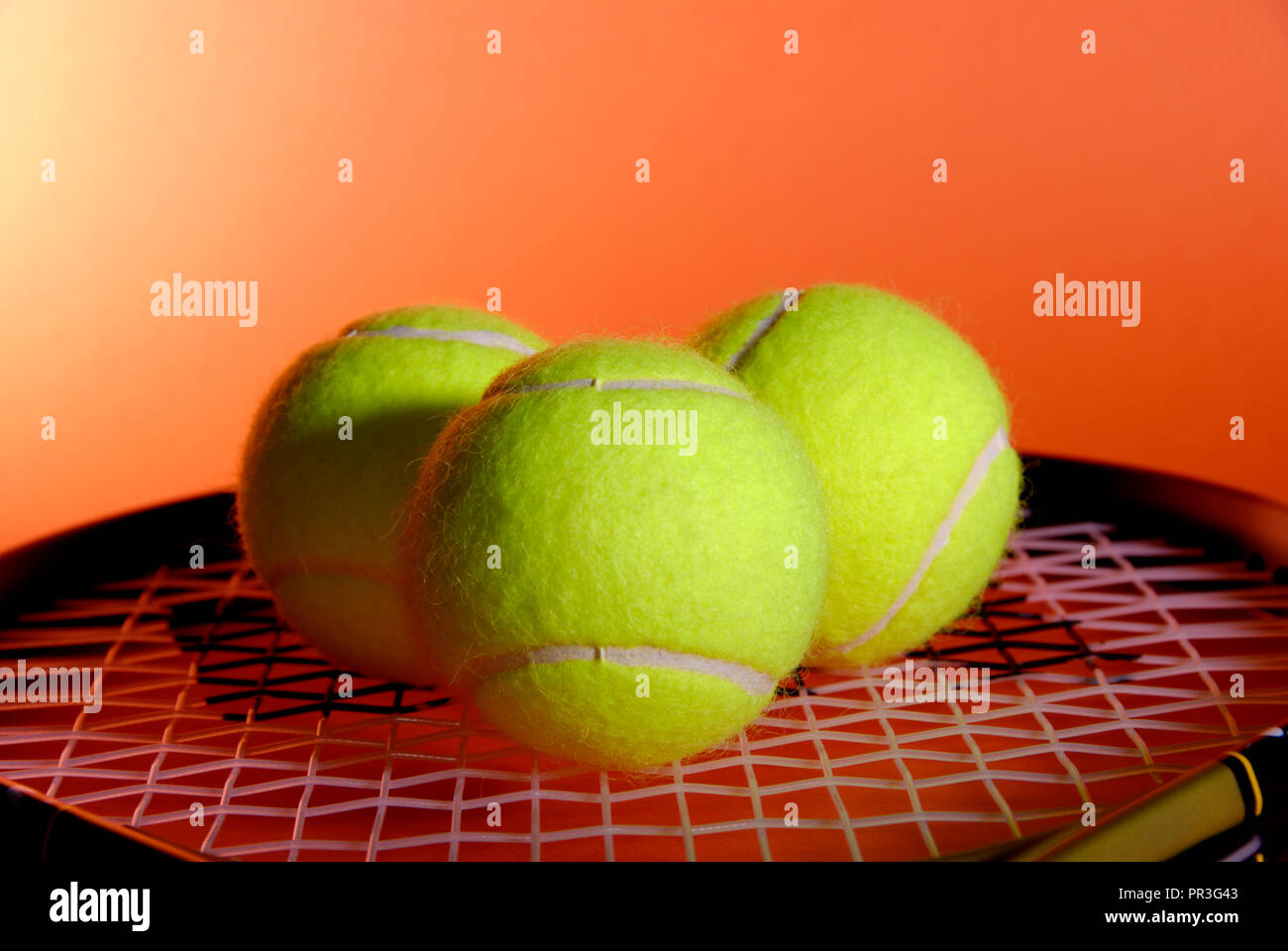three tennis balls on a racket Stock Photo - Alamy