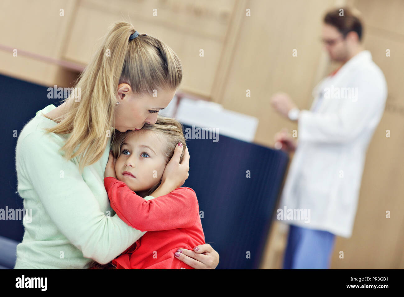 Little girl is crying while with her mother at a doctor on consultation ...