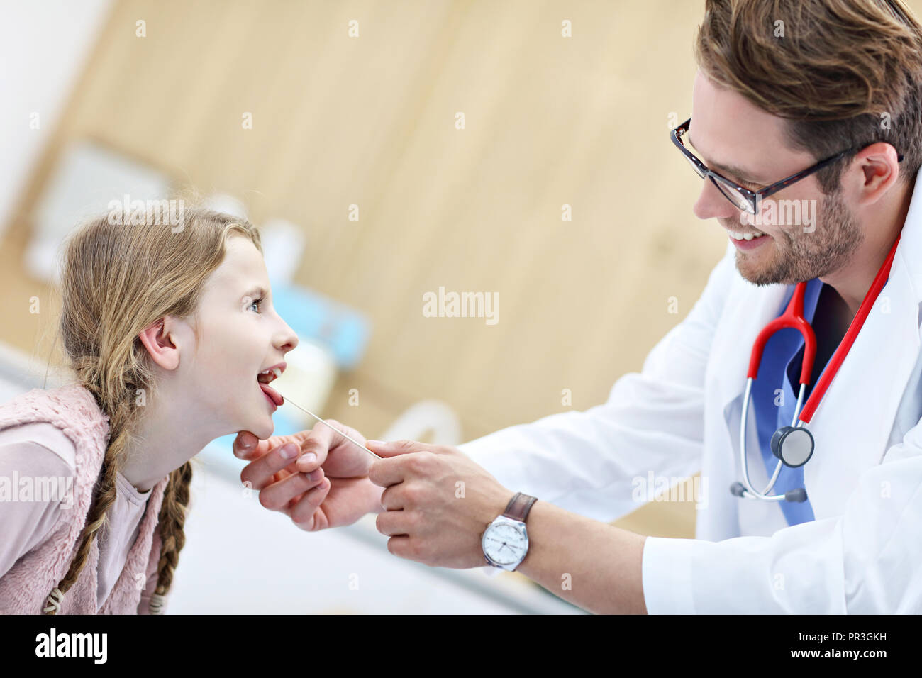 Little girl in clinic having a checkup with laryngologist Stock Photo ...
