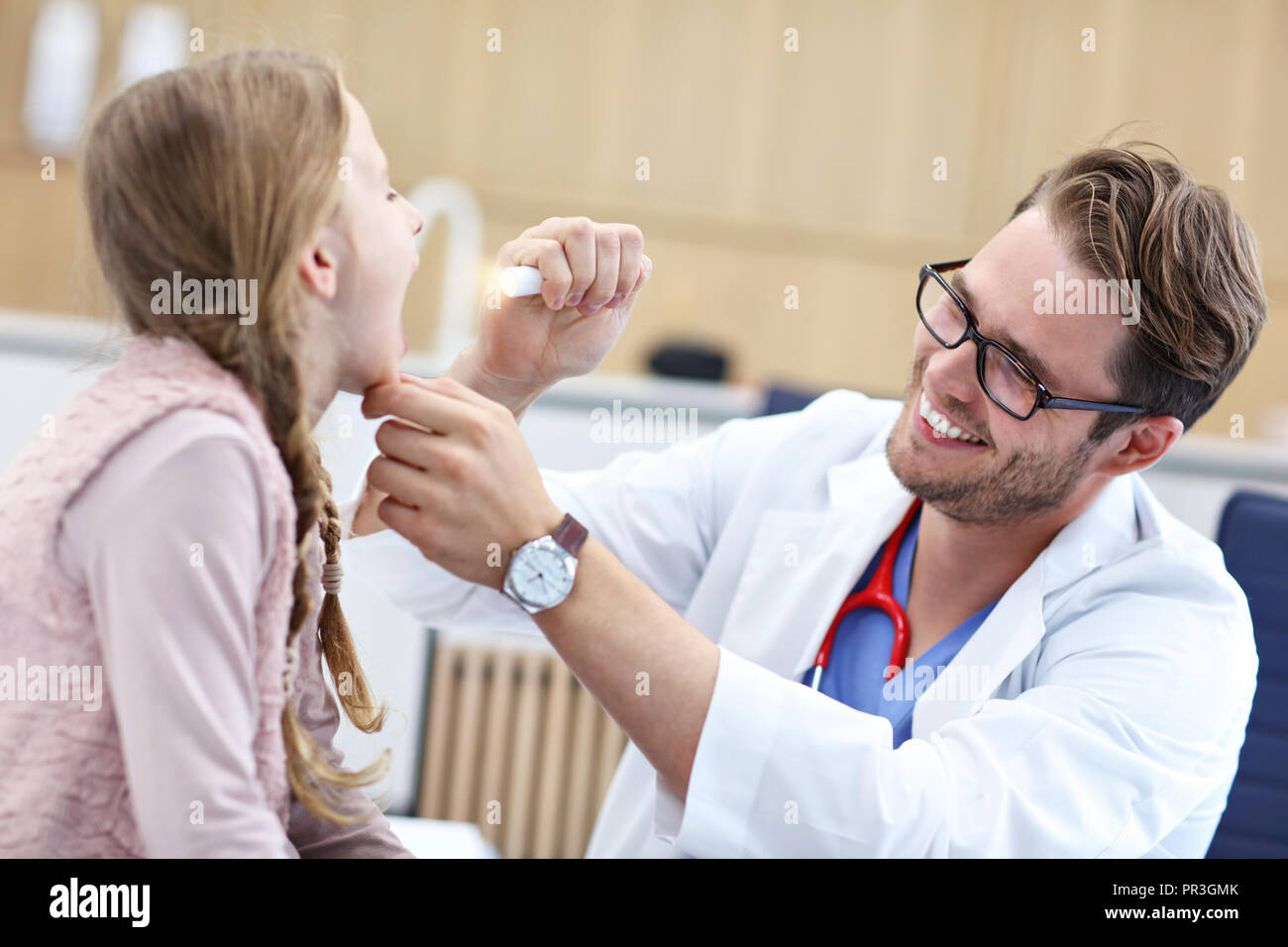 Little girl in clinic having a checkup with laryngologist Stock Photo ...