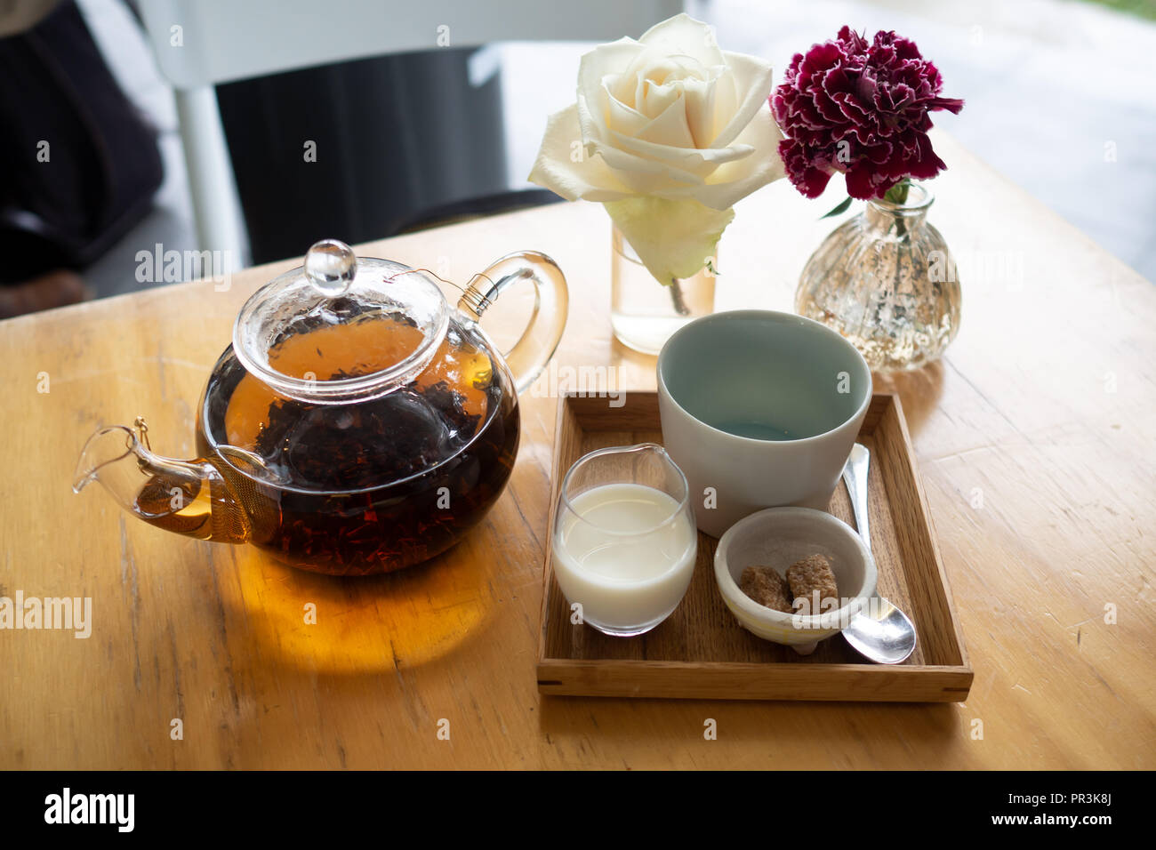 White rose next to fancy tea pot Stock Photo - Alamy