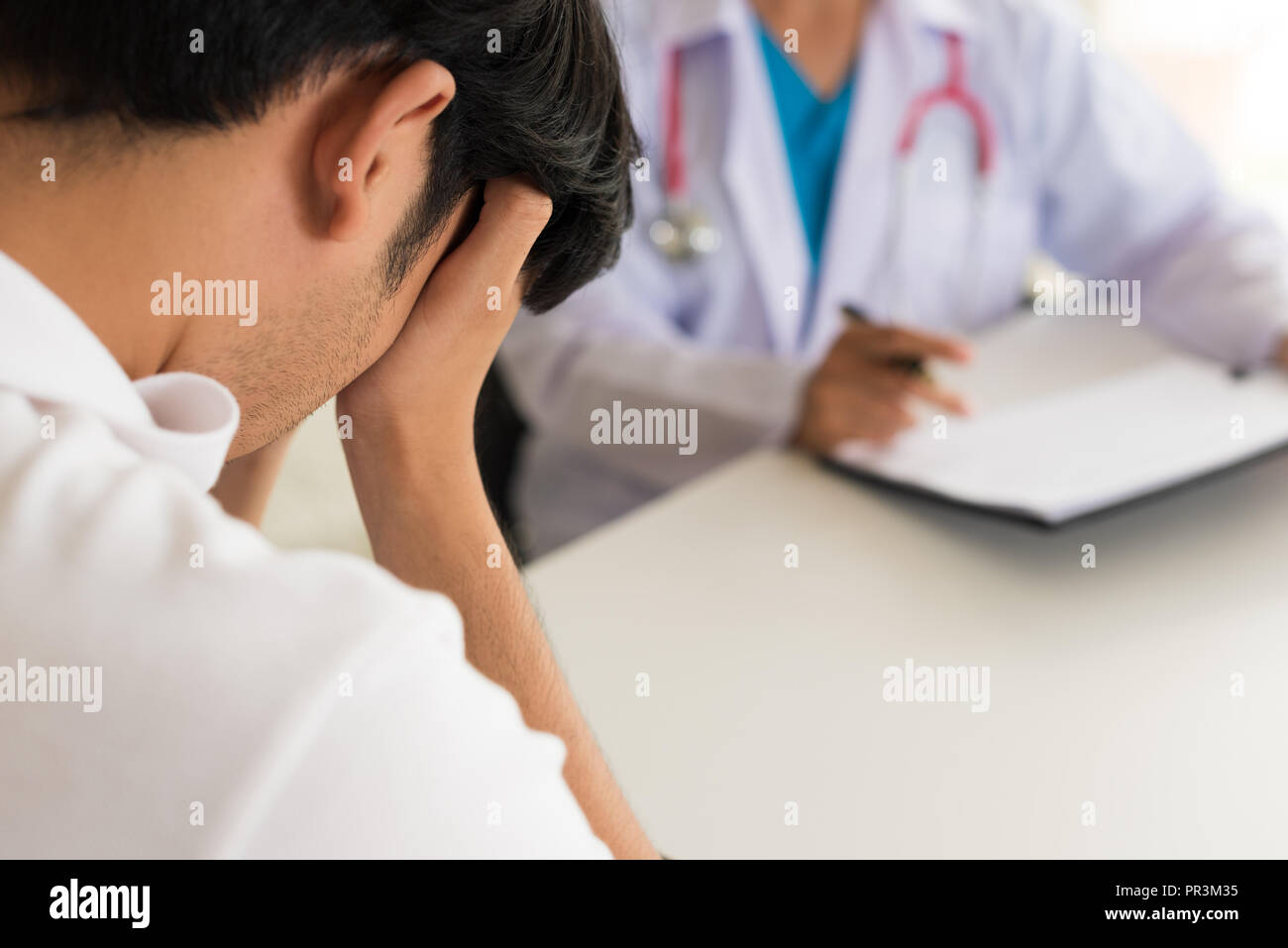 Female doctor have discussion with patient man covering face with hand ...