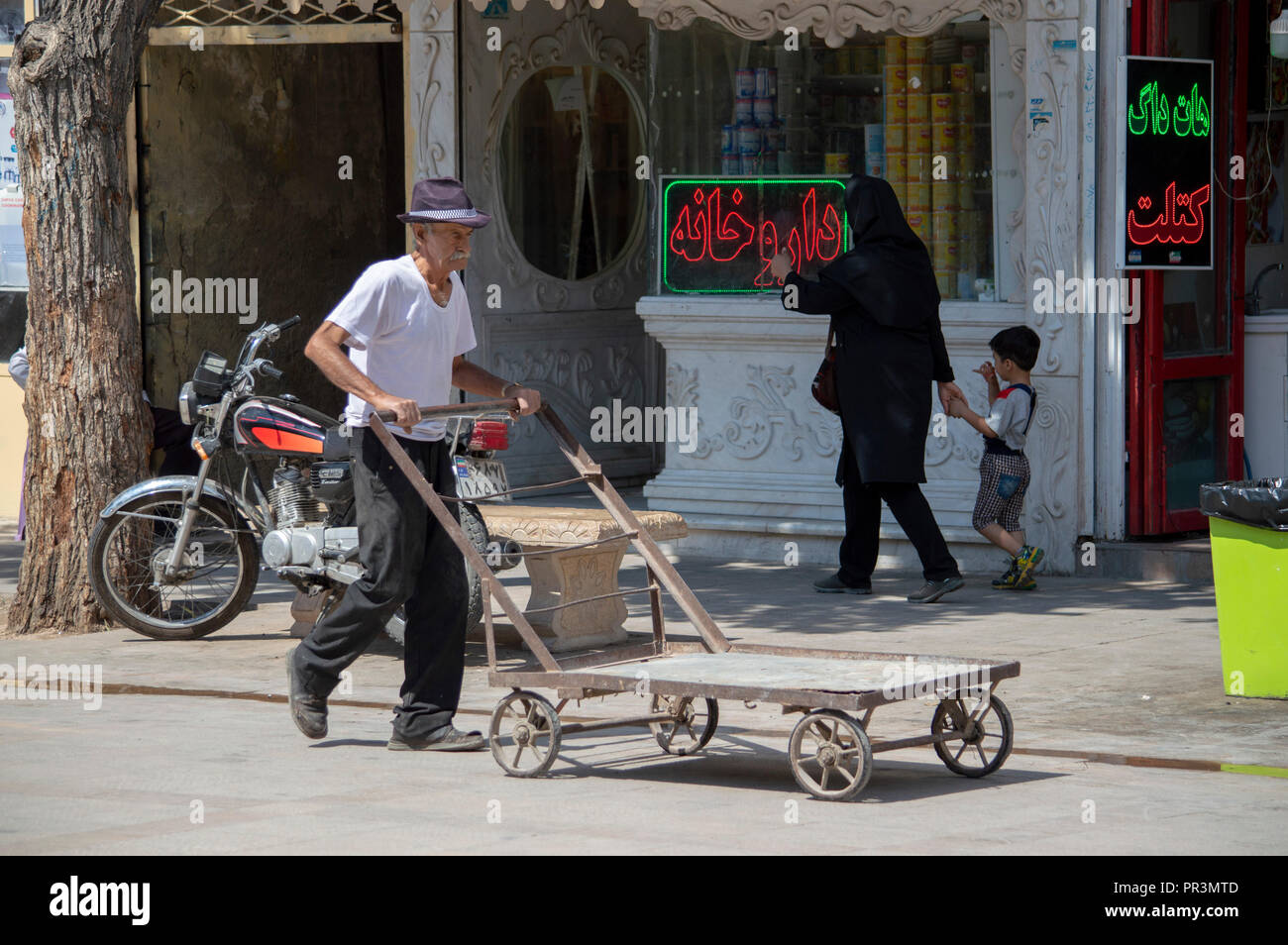 A man pushing a trolley in Shiraz, Iran Stock Photo - Alamy