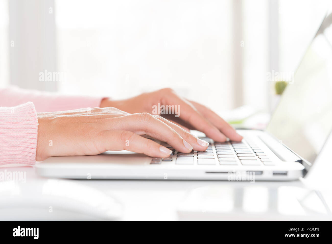 Closeup female hands typing on laptop keyboard. Woman working at home ...