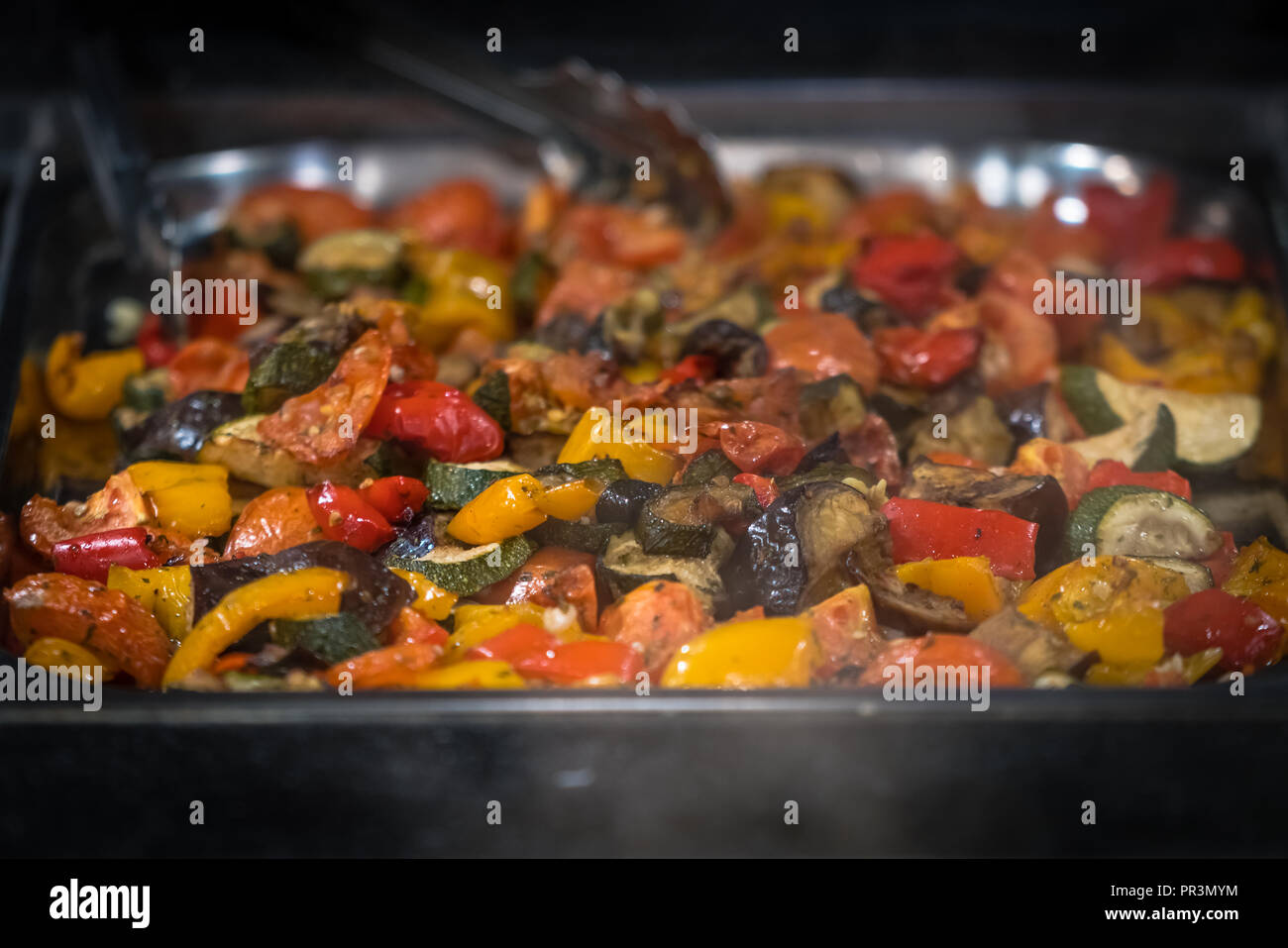 Roasted vegetables in tray on the self service hot counter in a self ...