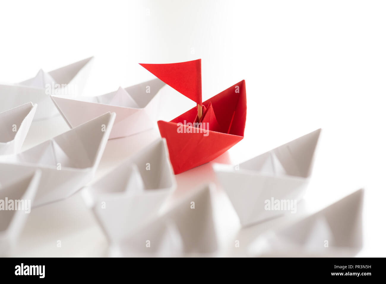 Leadership concept. red paper ship lead among white. One leader ship ...