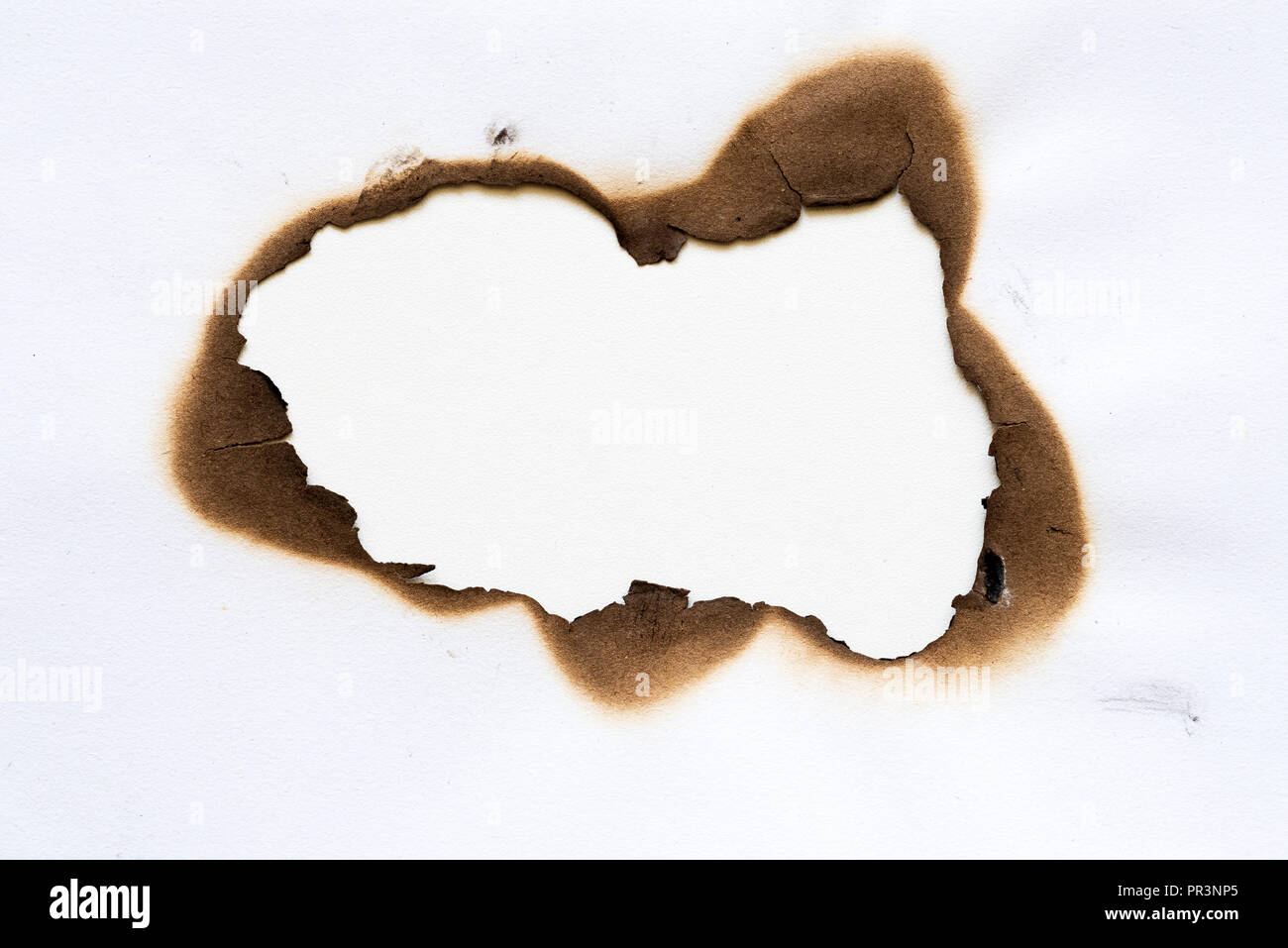 burned hole on piece of paper isolated on white background Stock Photo ...