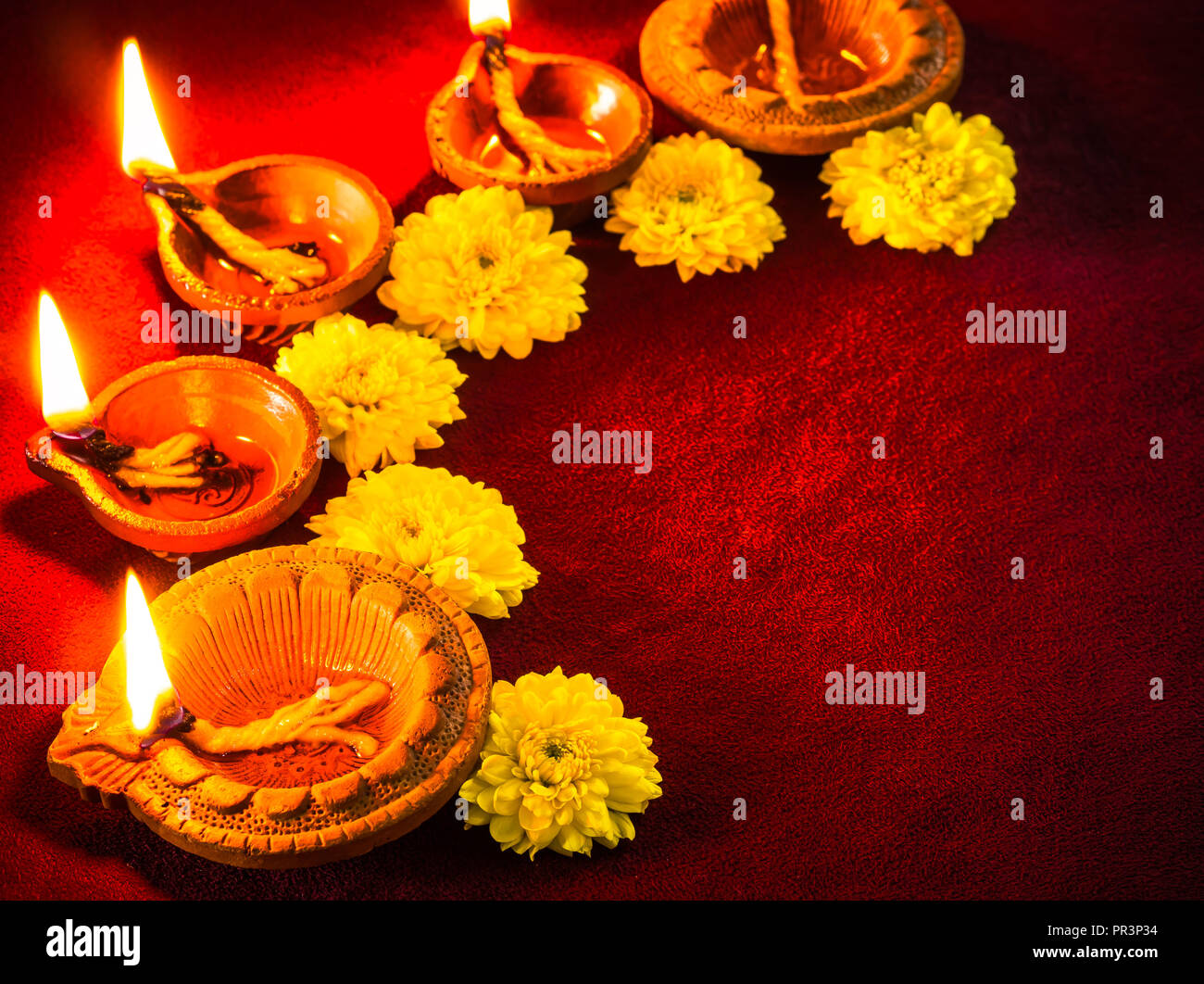 Traditional clay diya lamps lit with flowers for Diwali festival ...