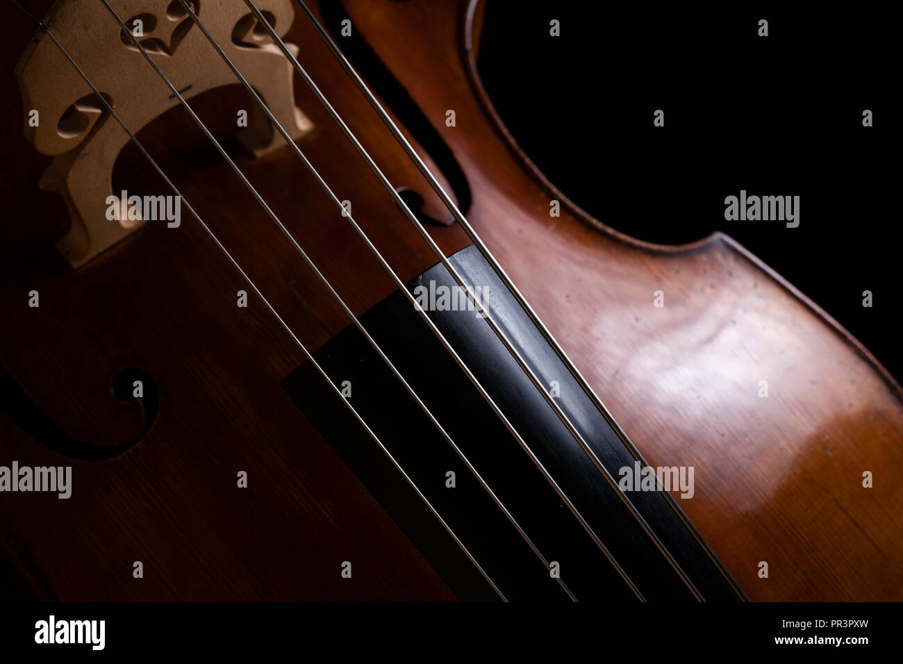 A part of a double bass on a dark background Stock Photo - Alamy
