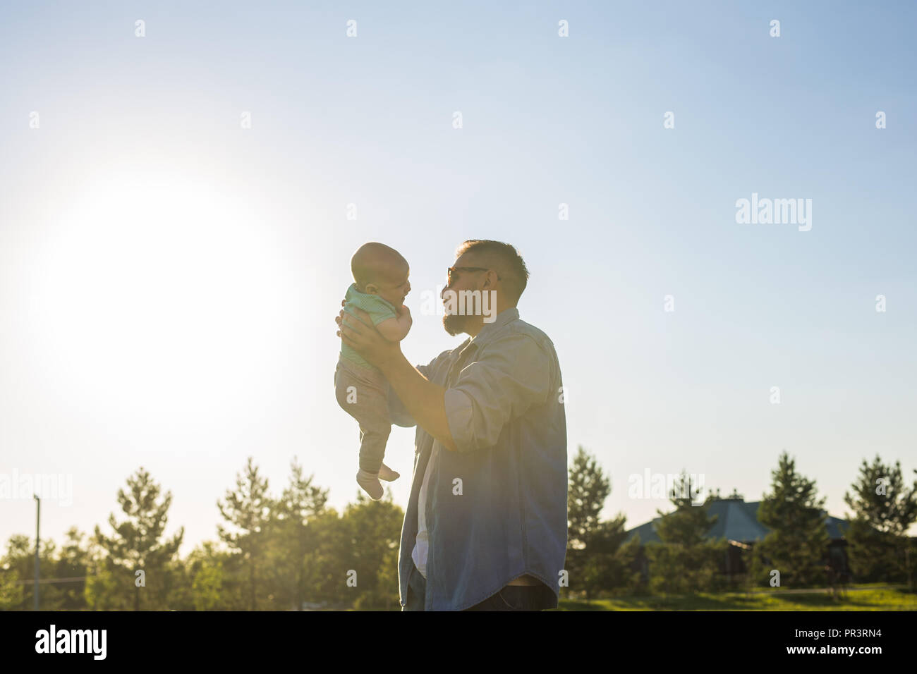 Happy father holding baby son on nature. Concept of happy family ...