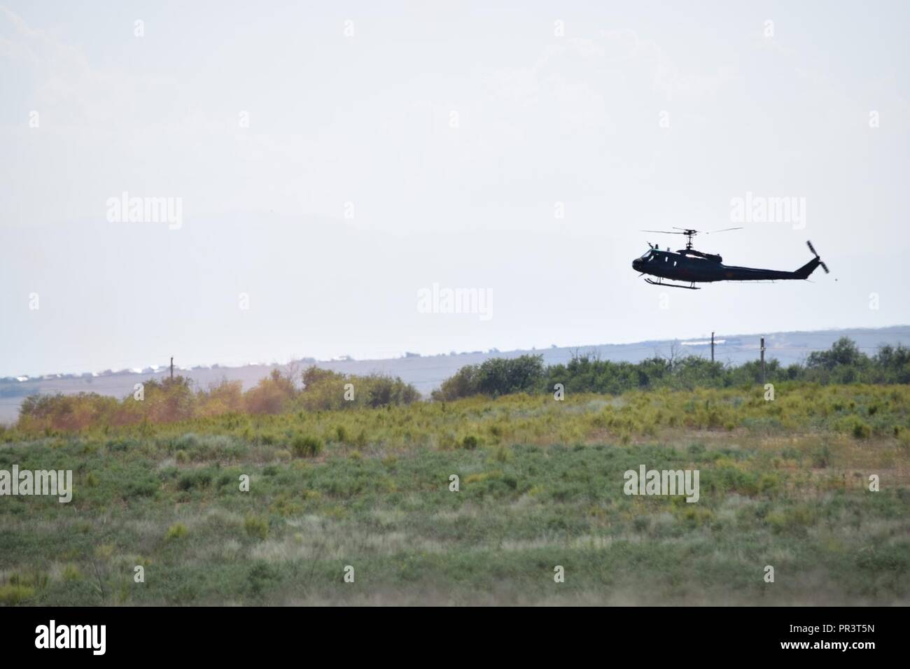 A medical evacuation helicopter lands in the distance to pick up ...