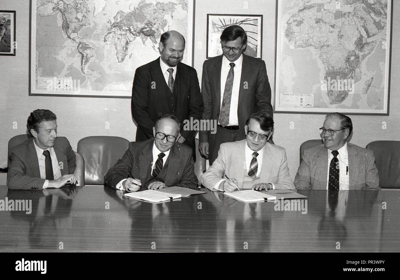 Men at a table signing papers hi-res stock photography and images - Alamy