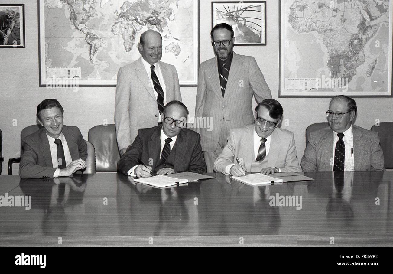 Men at a table signing papers hi-res stock photography and images - Alamy