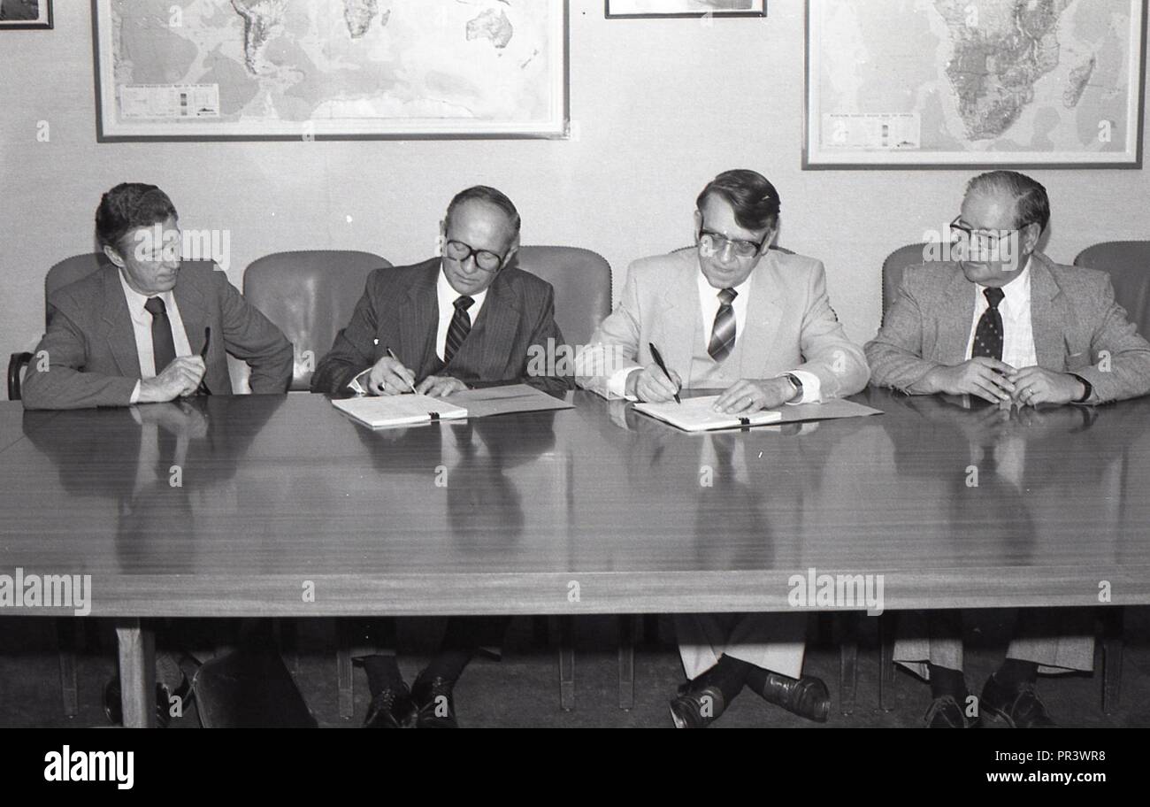 Men at a table signing papers hi-res stock photography and images - Alamy