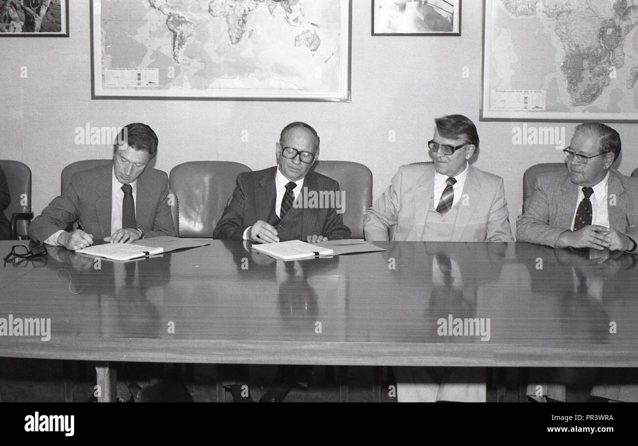 Men at a table signing papers hi-res stock photography and images - Alamy
