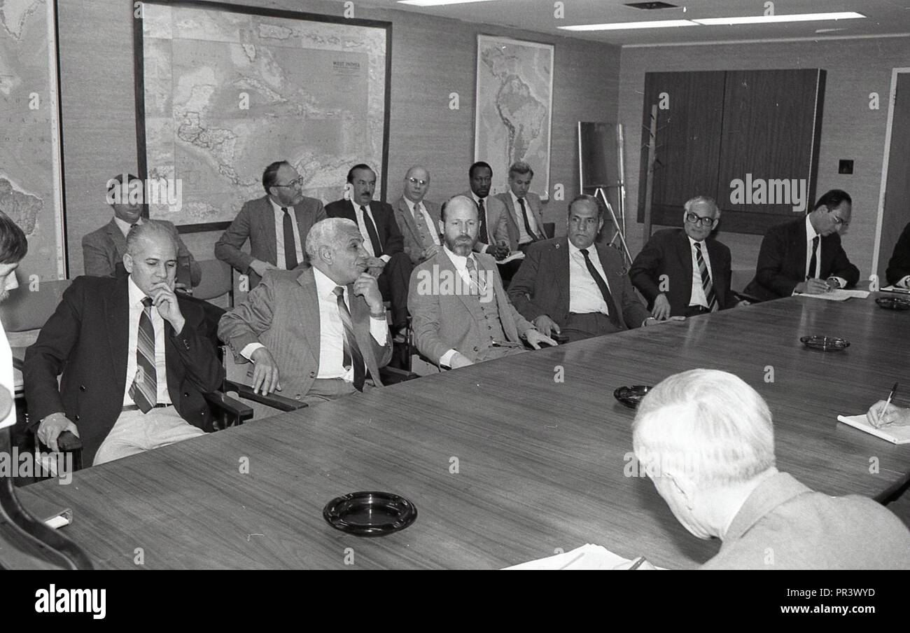 THERE ARE A GROUP OF MEN SITTING AROUND THE TABLE IN A MEETING Stock ...
