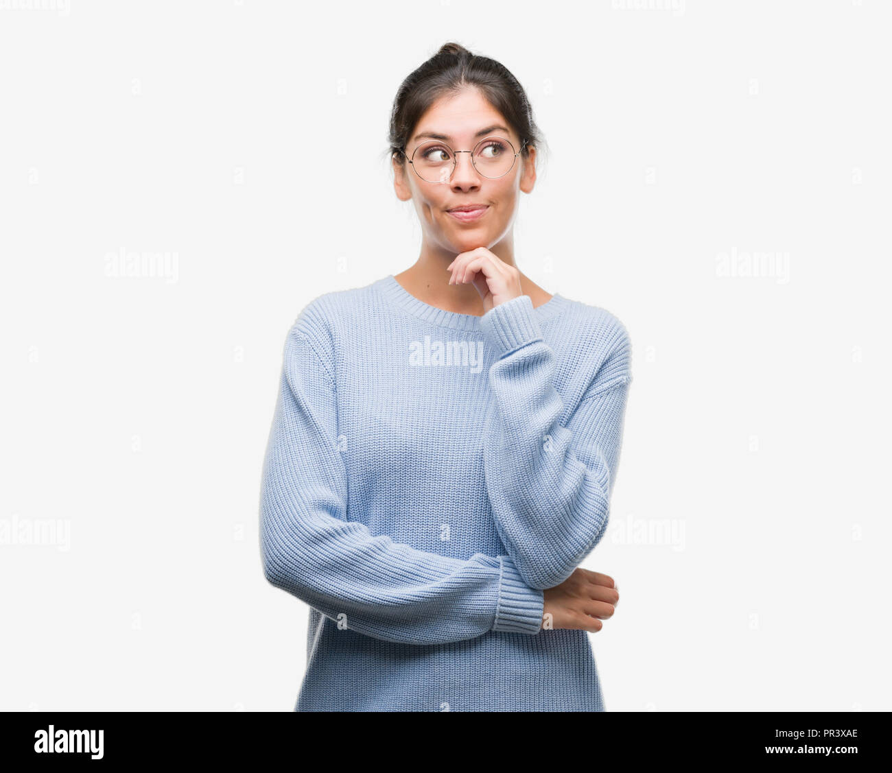 Young beautiful hispanic woman wearing a bun serious face thinking ...