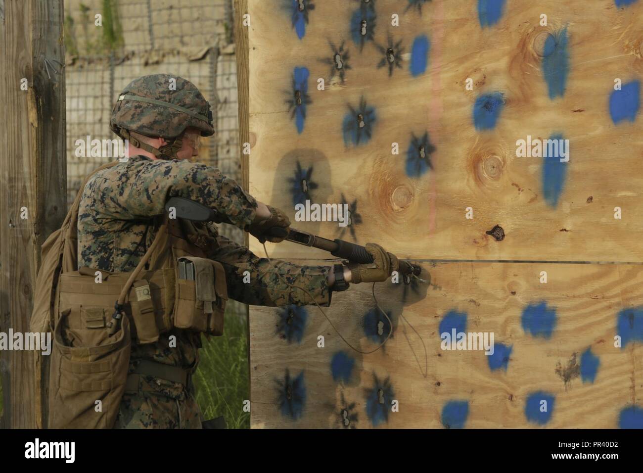 A Marine uses an M500 shotgun to practice breaching a door during urban ...
