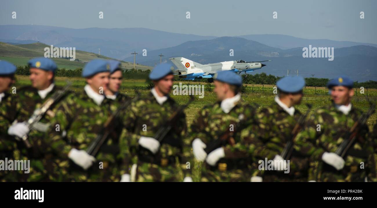 Romanian airmen look at a Mikoyan-Gurevich MiG-21 aircraft take off ...